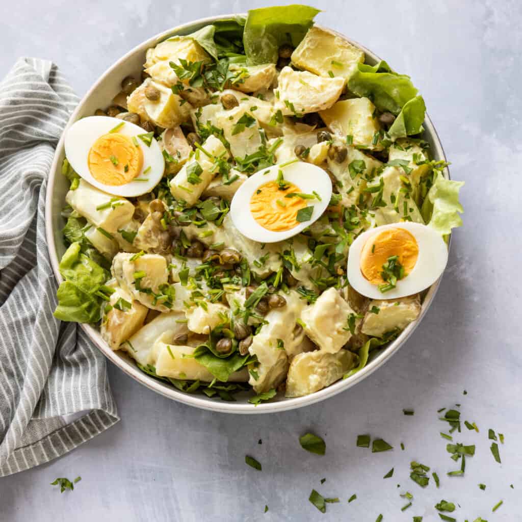 Lauwwarme aardappelsalade met witte asperge, kropsla, ei en bieslook